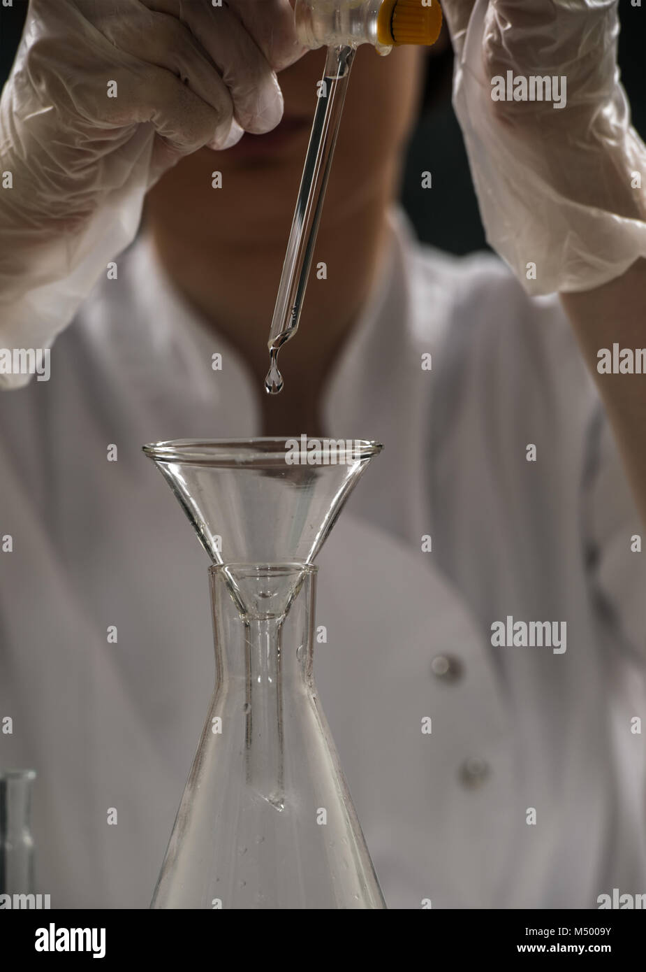 Unrecognizable science professional pipetting liquid into the glass ...