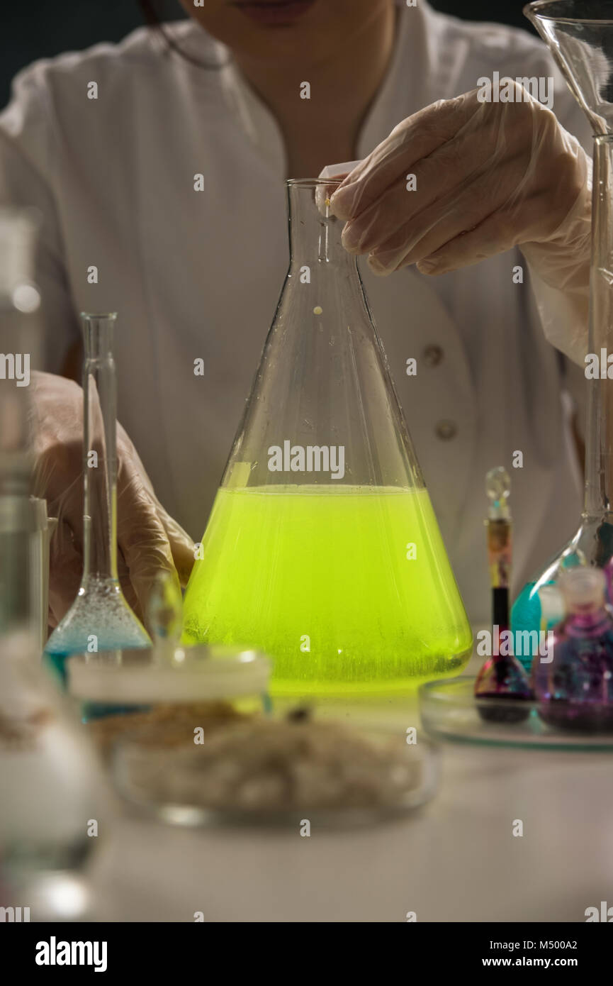 Scientist working with test tubes, flask and other glassware. Woman ...
