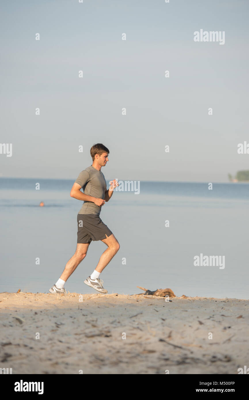 Man athlete/runner running on beach - jog workout well-being concept ...