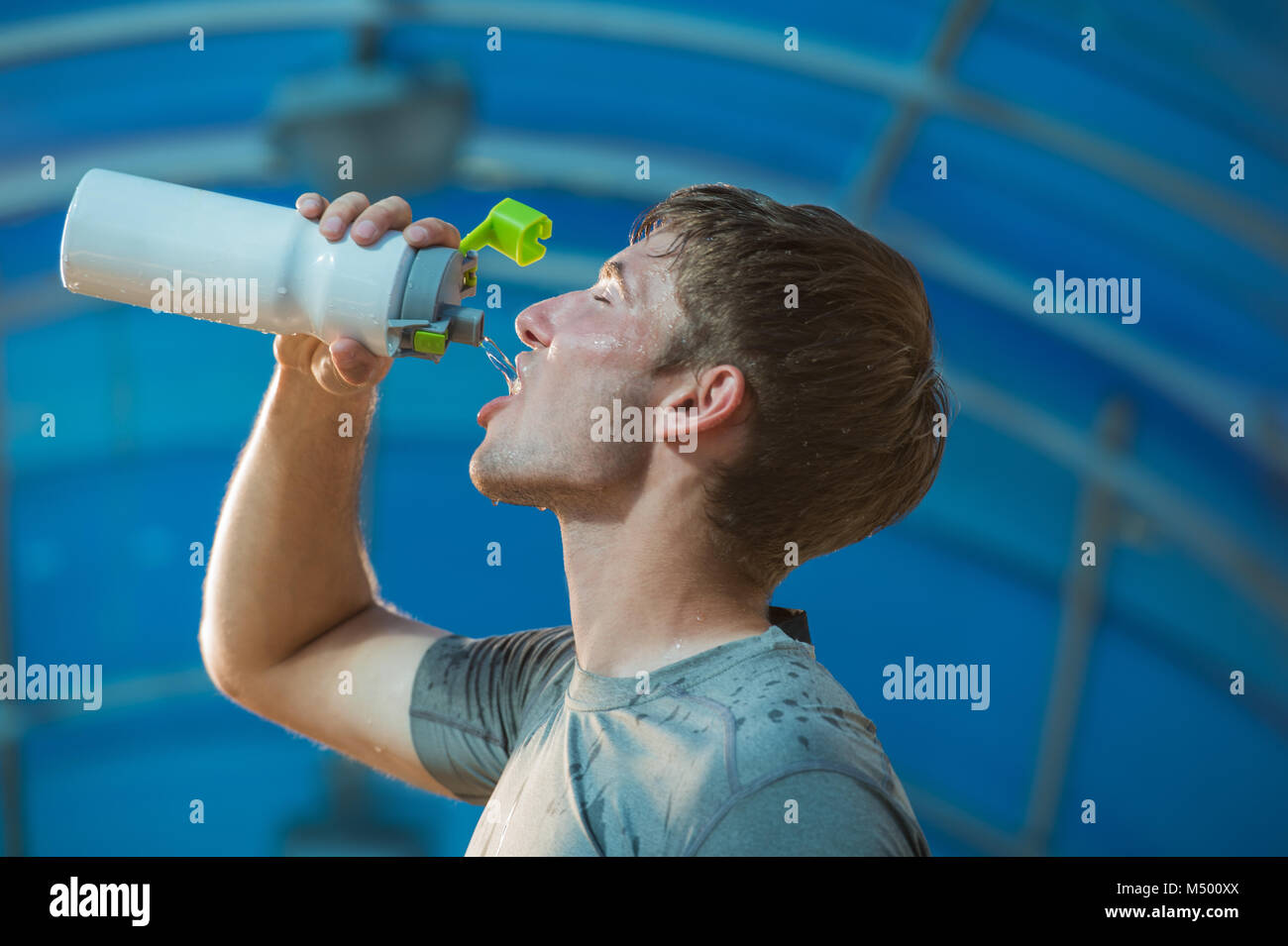 Athletic young man drinking water after hard training Stock Photo - Alamy