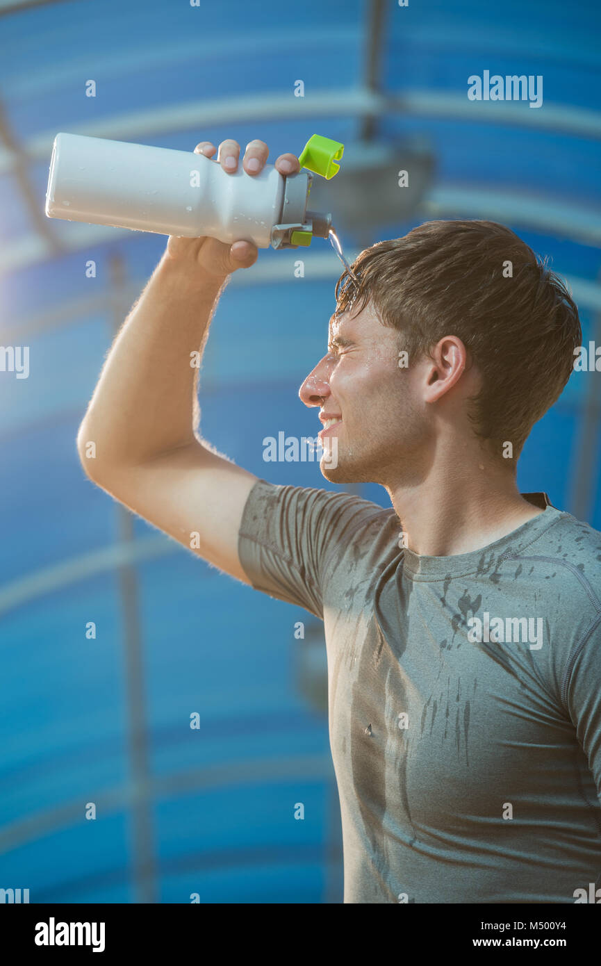 Athletic young man drinking water after hard training Stock Photo - Alamy