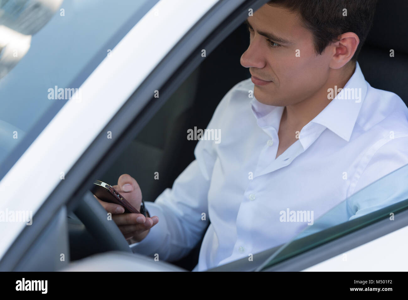 The young man behind the wheel driving car and calling phone Stock ...
