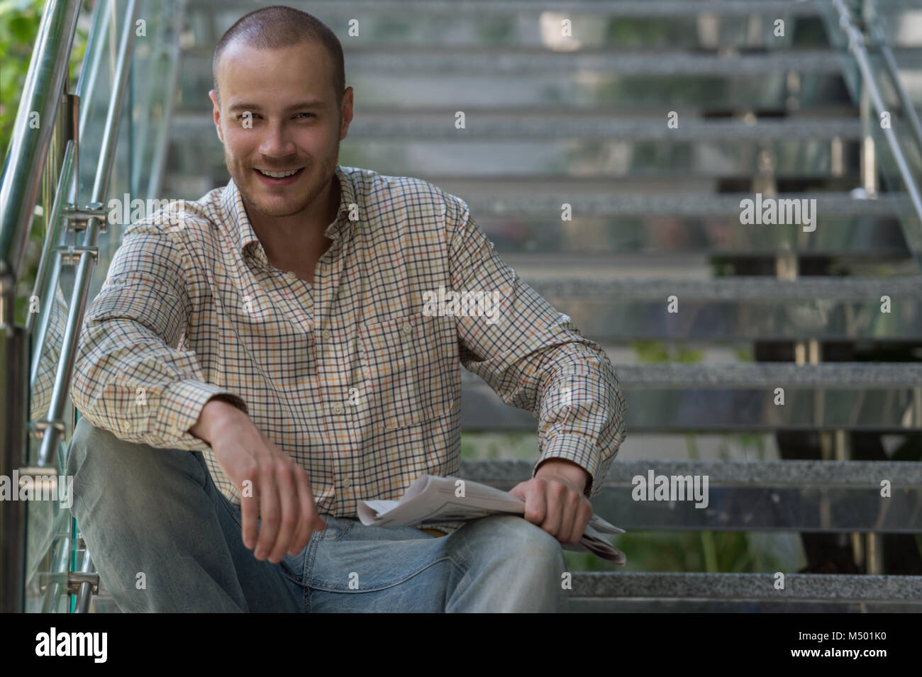 Handsome man reading a newspaper and thinking Stock Photo - Alamy