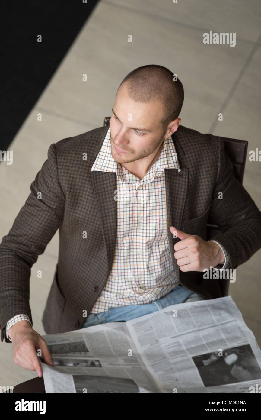 Handsome businessman or manager in office building reading newspaper ...