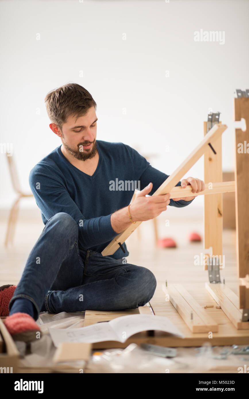 Man Putting Together Self Assembly Furniture In New Home Stock Photo ...