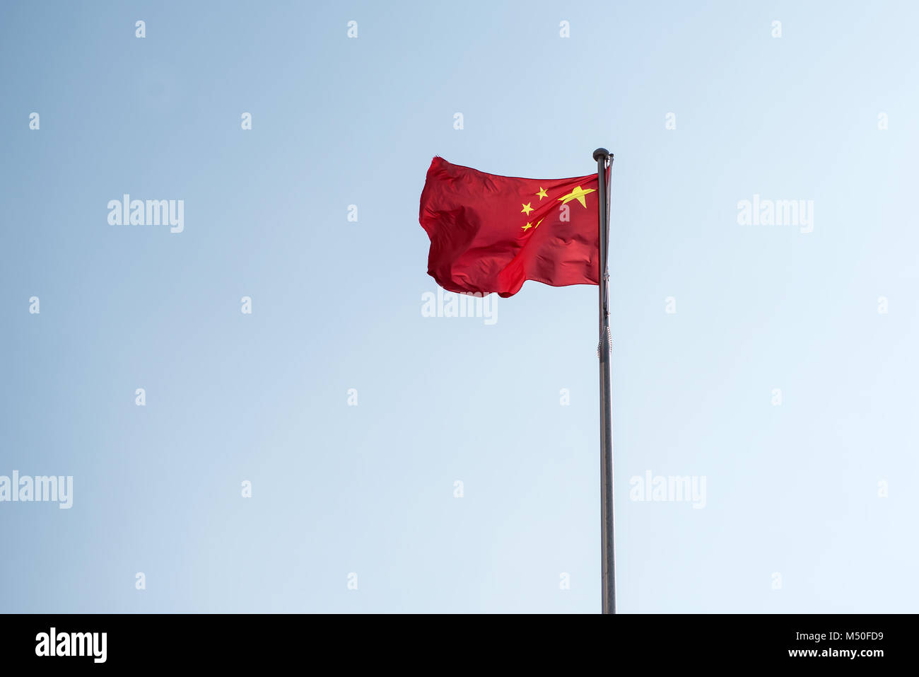 The Chinese flag flies in the blue sky Stock Photo - Alamy