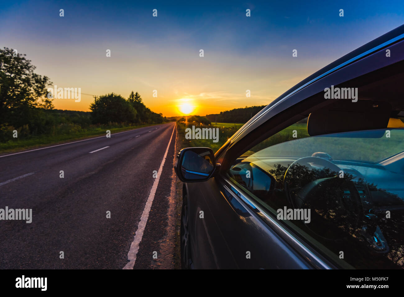 Car on the side of the road sunset Stock Photo - Alamy