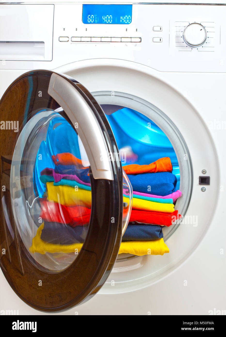 The washing machine with an open door and linen Stock Photo - Alamy