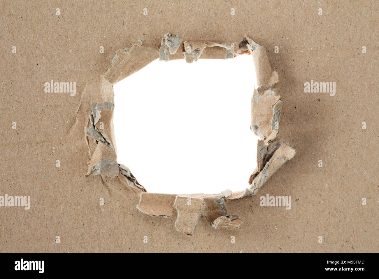 Ripped hole in brown cardboard. Copy-space Stock Photo - Alamy