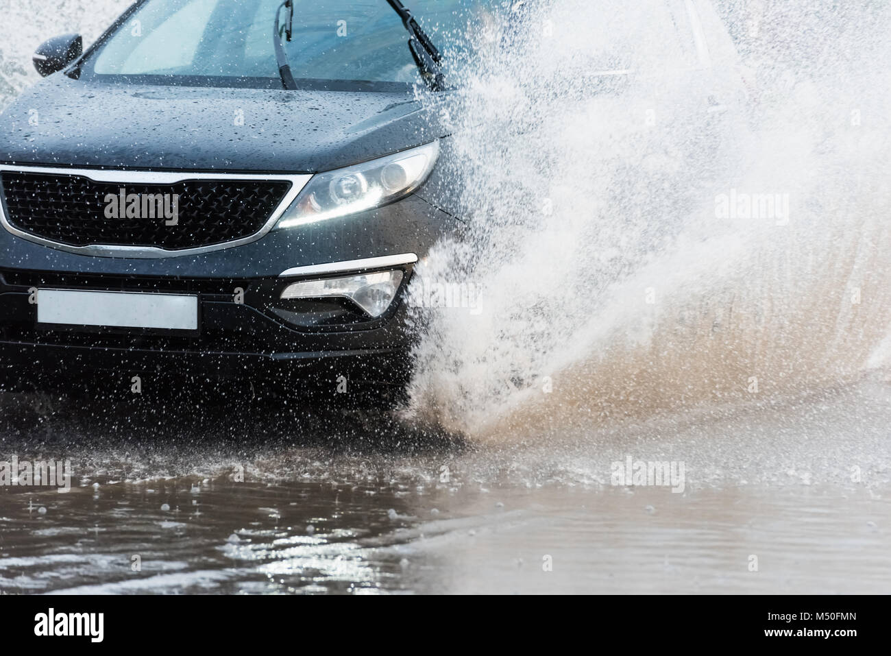 car rain puddle splashing water Stock Photo - Alamy