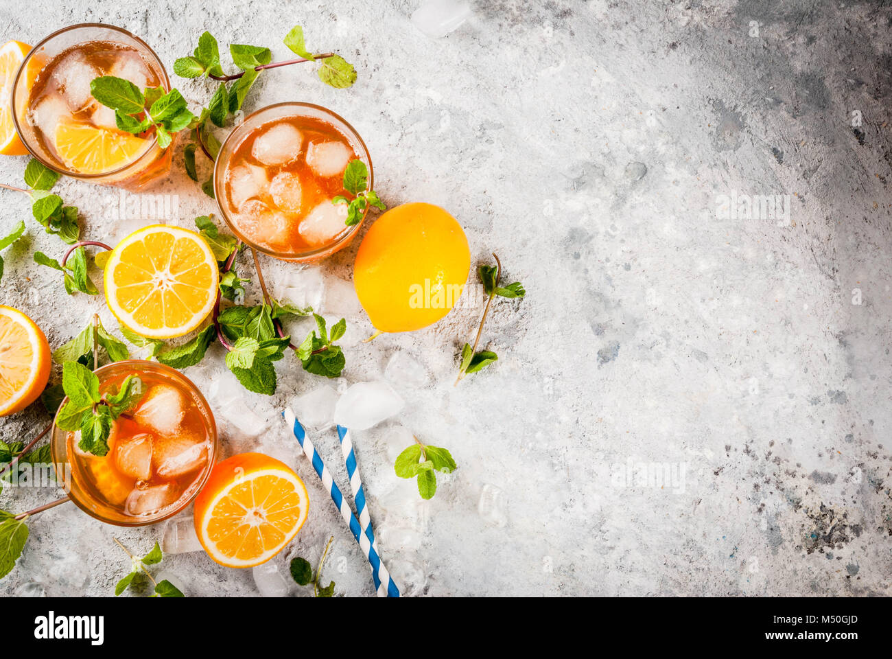 Cold summer drink. iced tea with lemon and mint, on grey stone ...