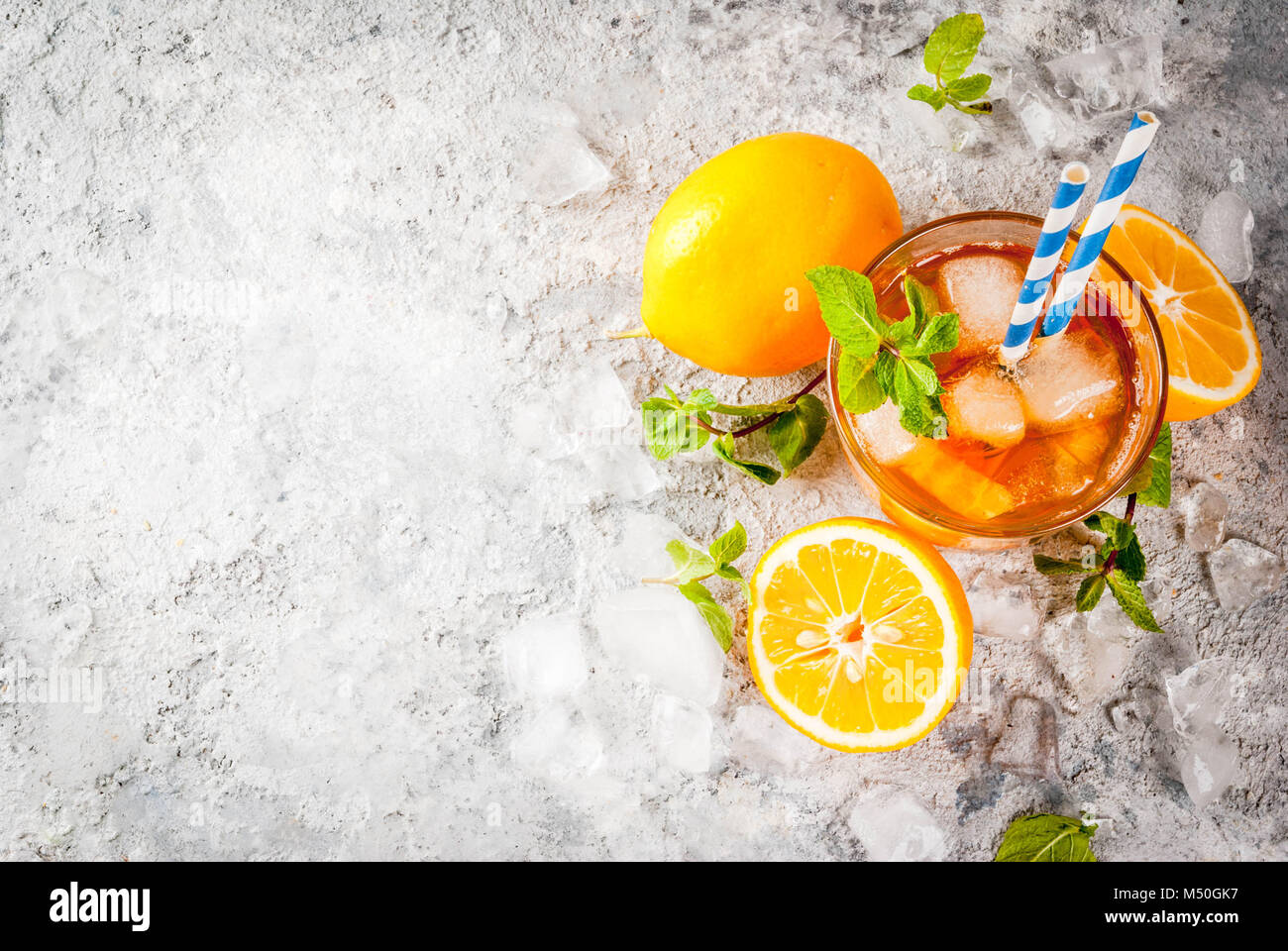 Cold summer drink. iced tea with lemon and mint, on grey stone ...
