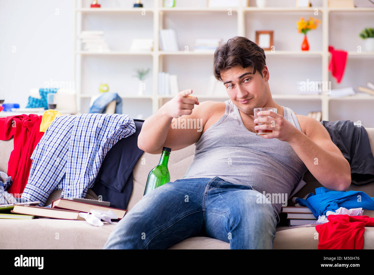 Young man student drunk drinking alcohol in a messy room Stock Photo ...
