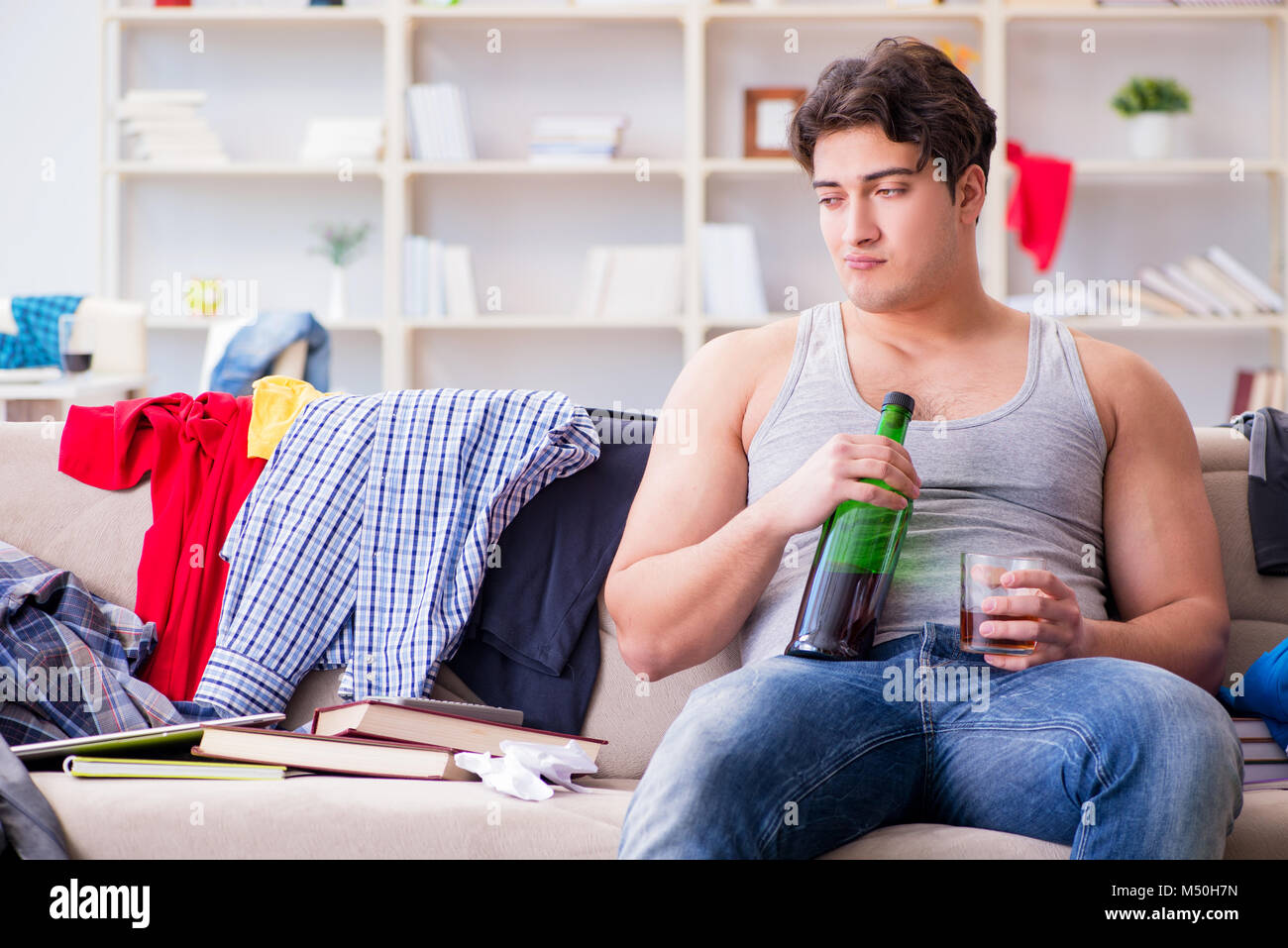 Young man student drunk drinking alcohol in a messy room Stock Photo ...