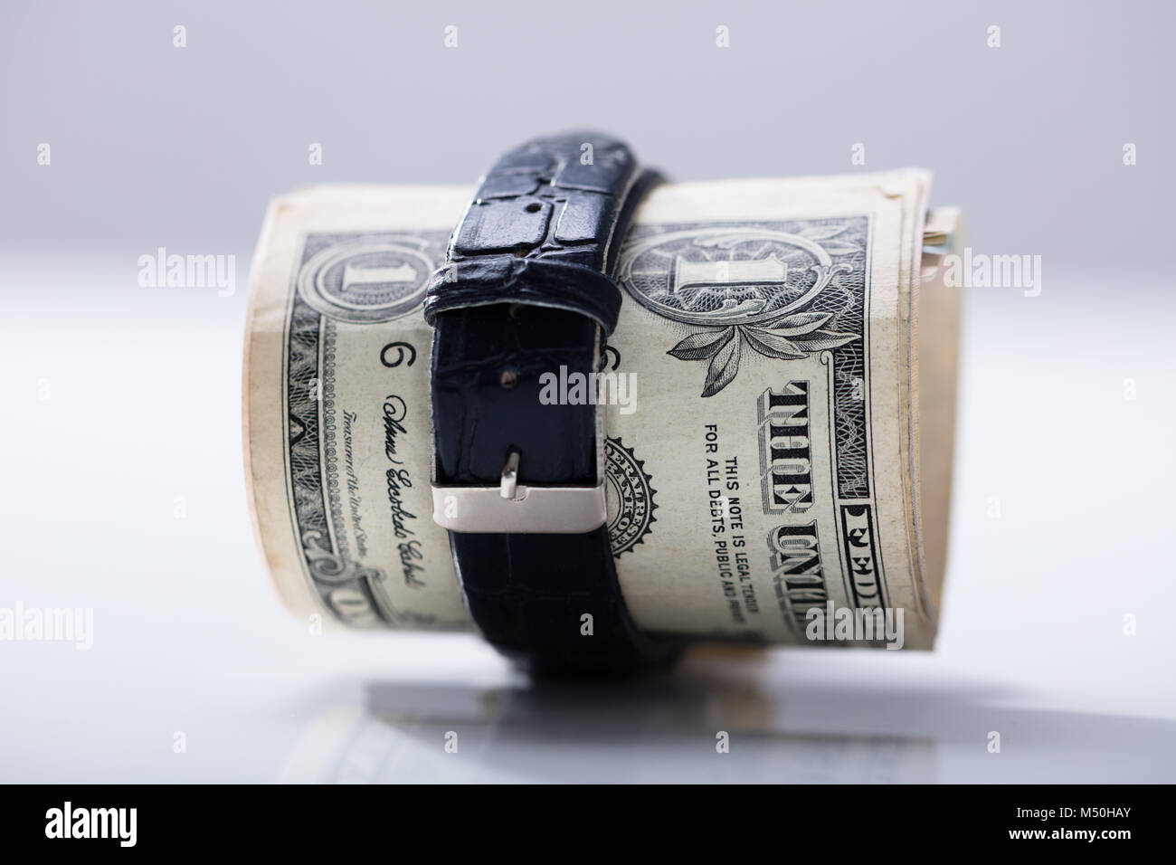 Rolled Up Dollar Banknote Tied With Belt Against White Background Stock ...