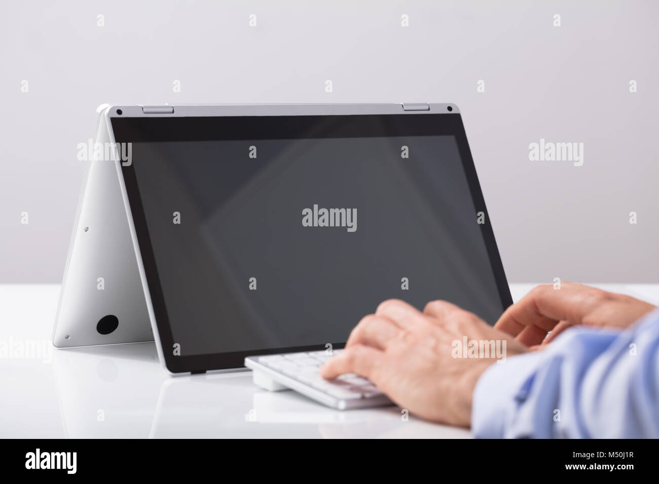 Hand Typing On The Keyboard In Front Of The Hybrid Laptop Over The Desk ...