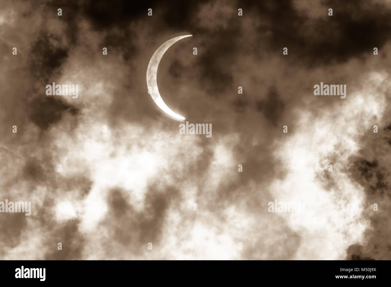 Partial Solar Eclipse Through Clouds Stock Photo - Alamy
