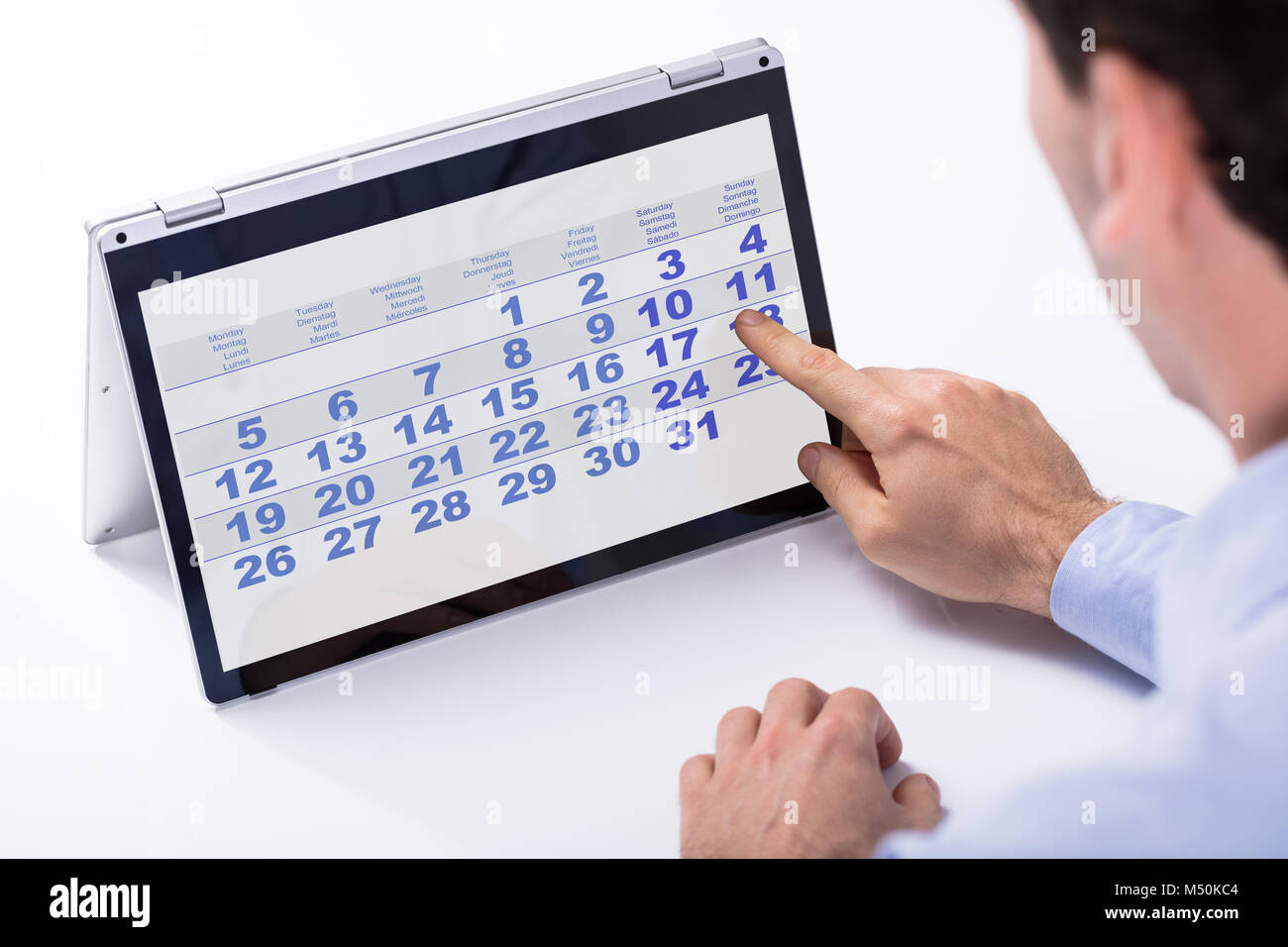 Close-up Of Businessman Pointing On The Calendar Over Hybrid Laptop ...
