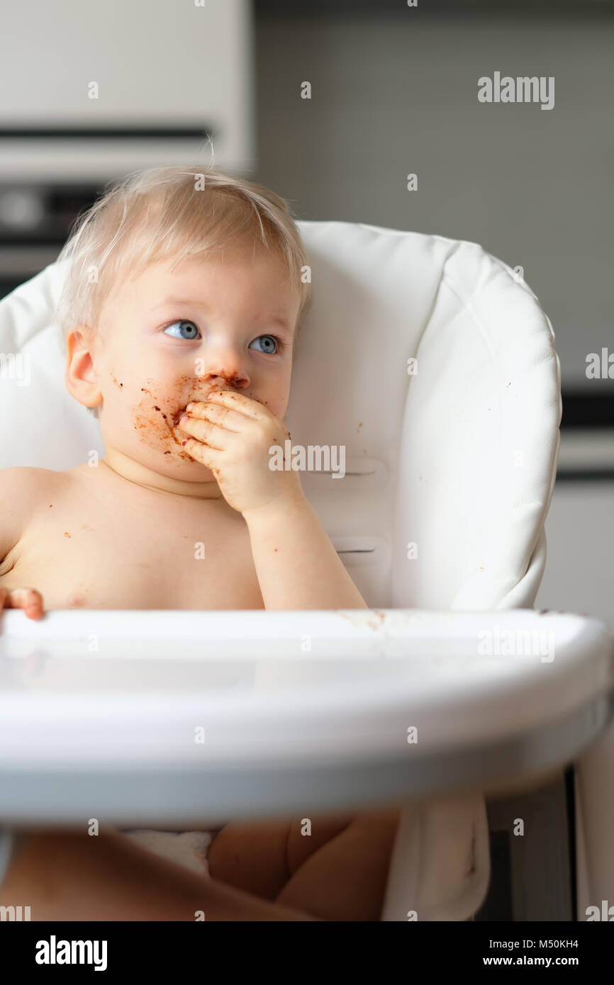 Toddler baby boy child eating fruit with dirty messy face Stock Photo ...