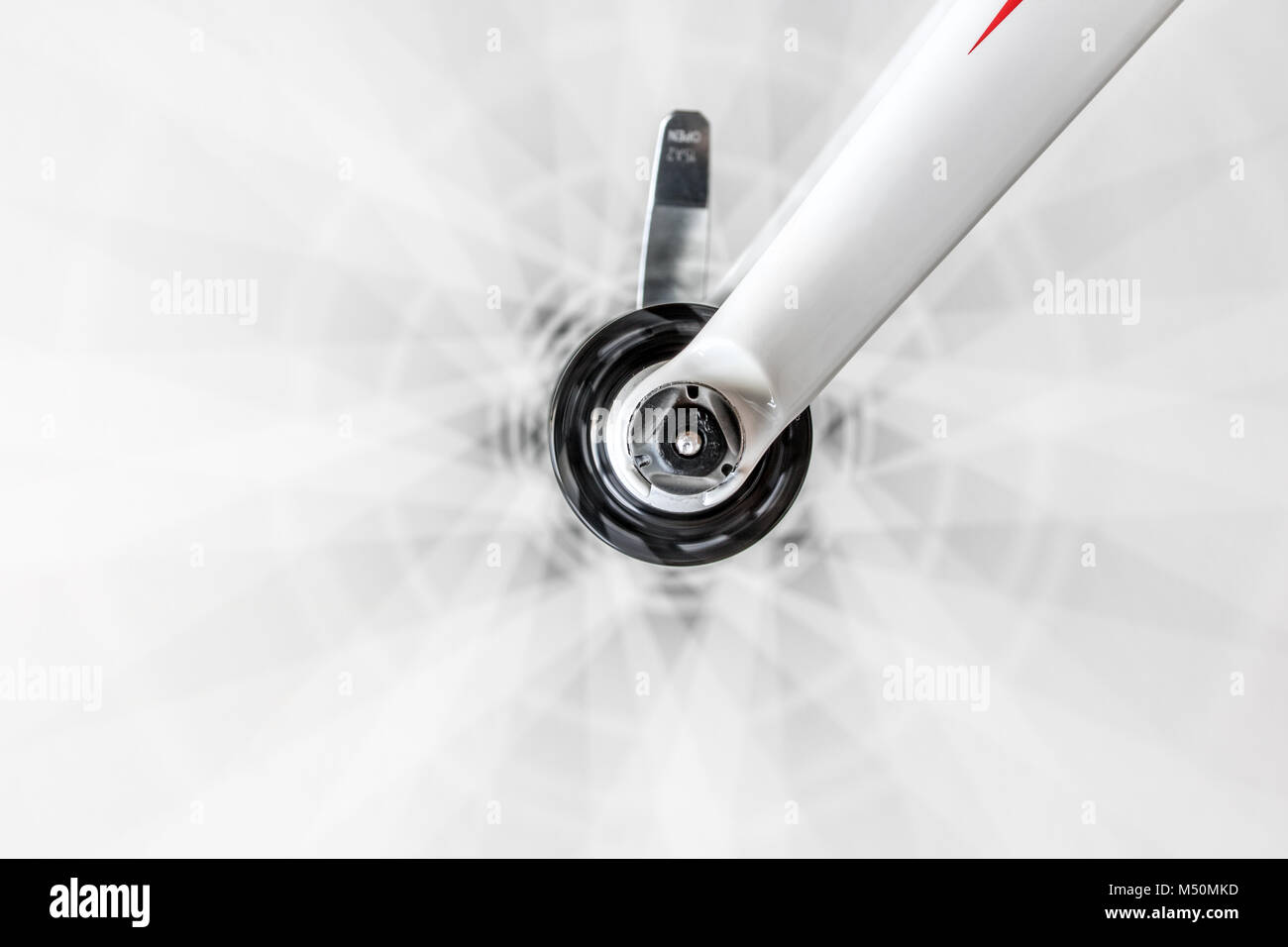 The front wheel of the bicycle rotates quickly on a white background ...