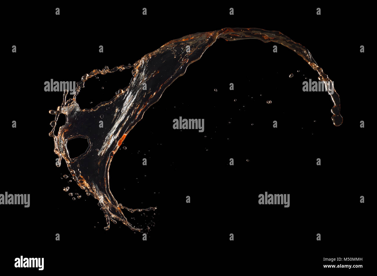 splash of ink isolated on black background. golden splash close-up ...