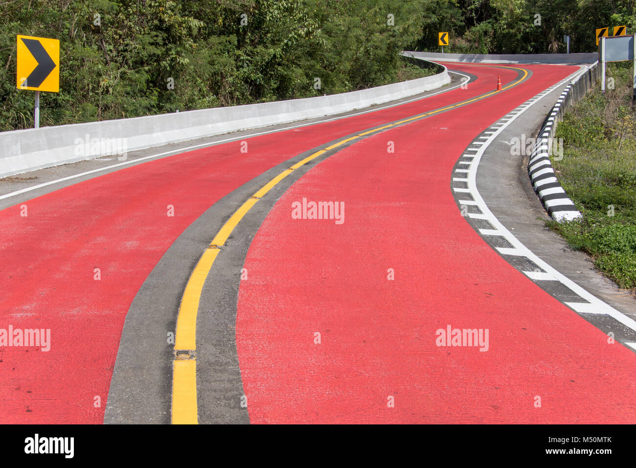 Empty red road with curves. Warning road surface with serpentines in ...