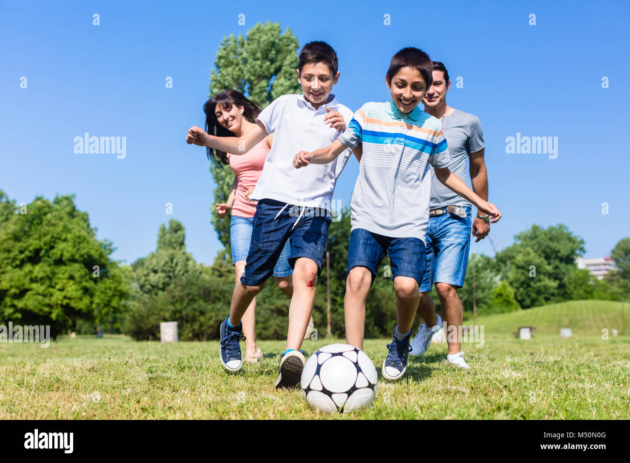 Family playing football or soccer in park in summer Stock Photo - Alamy