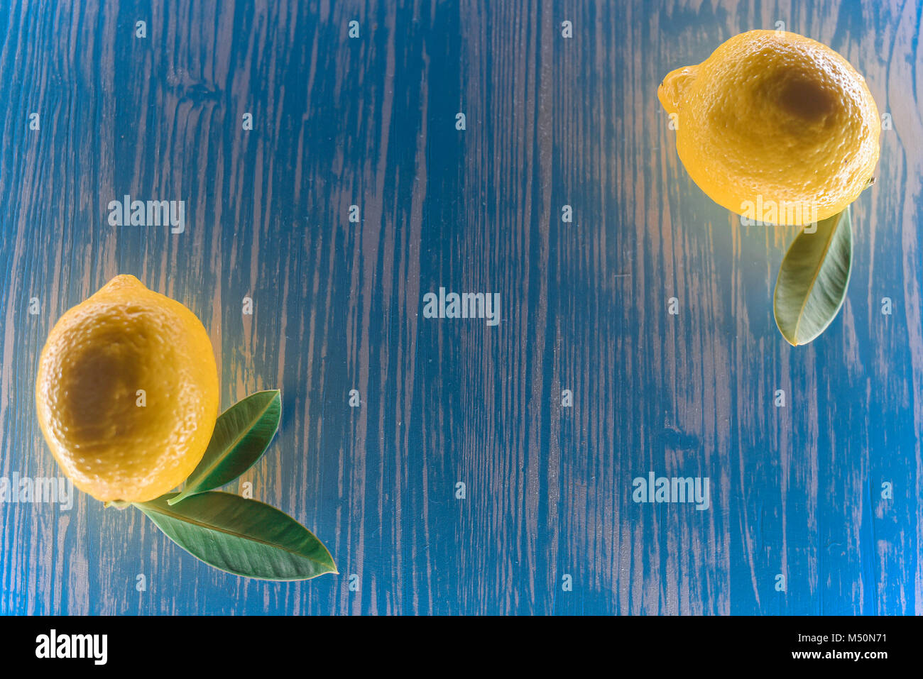 lemon lying on a wooden table with leaves Stock Photo - Alamy