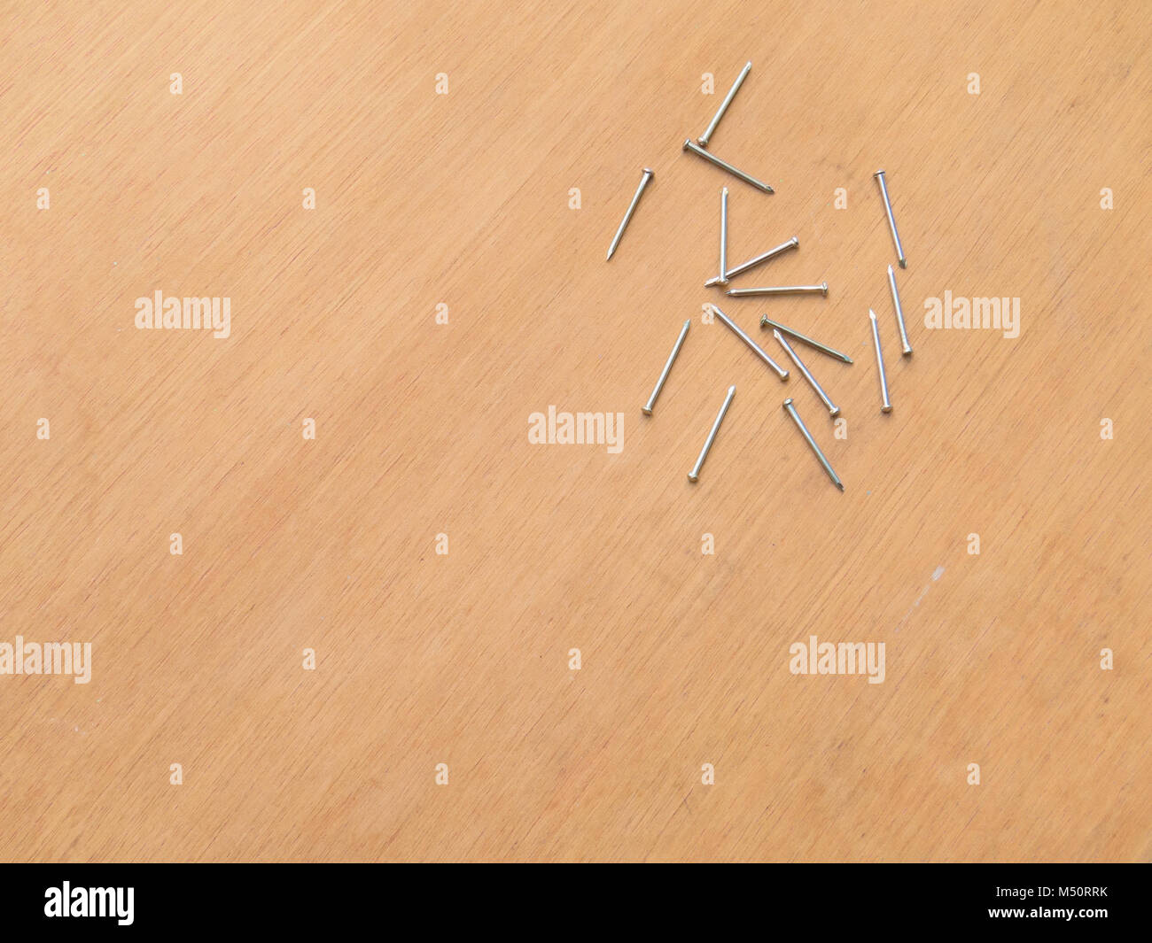 Several new nails on wooden background board Stock Photo - Alamy