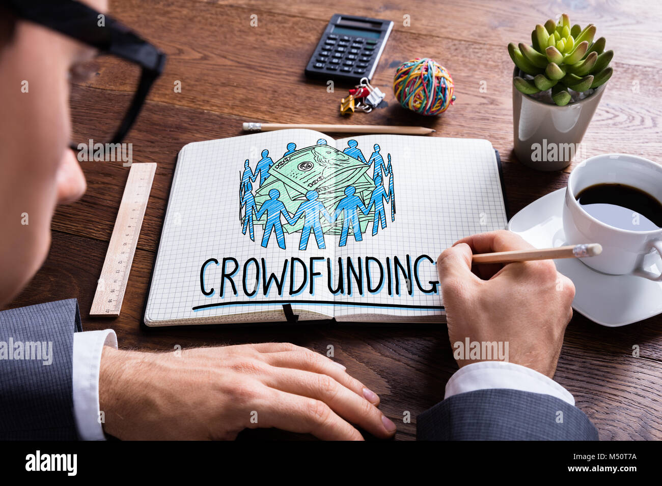 Man Drawing Crowdfunding Concept In Notepad At Desk Stock Photo - Alamy