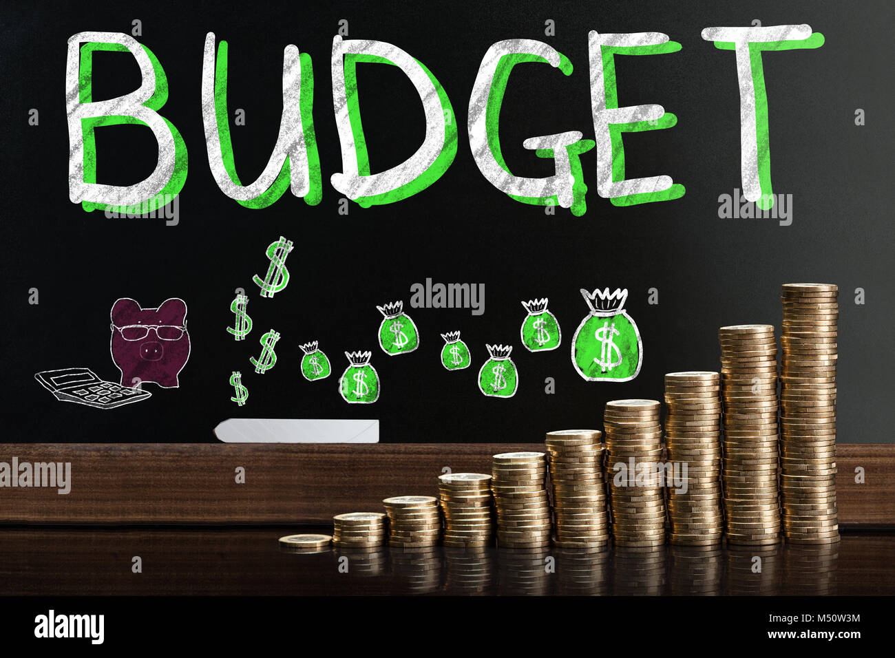 Budget Word On Blackboard Behind Stacked Coins Stock Photo - Alamy