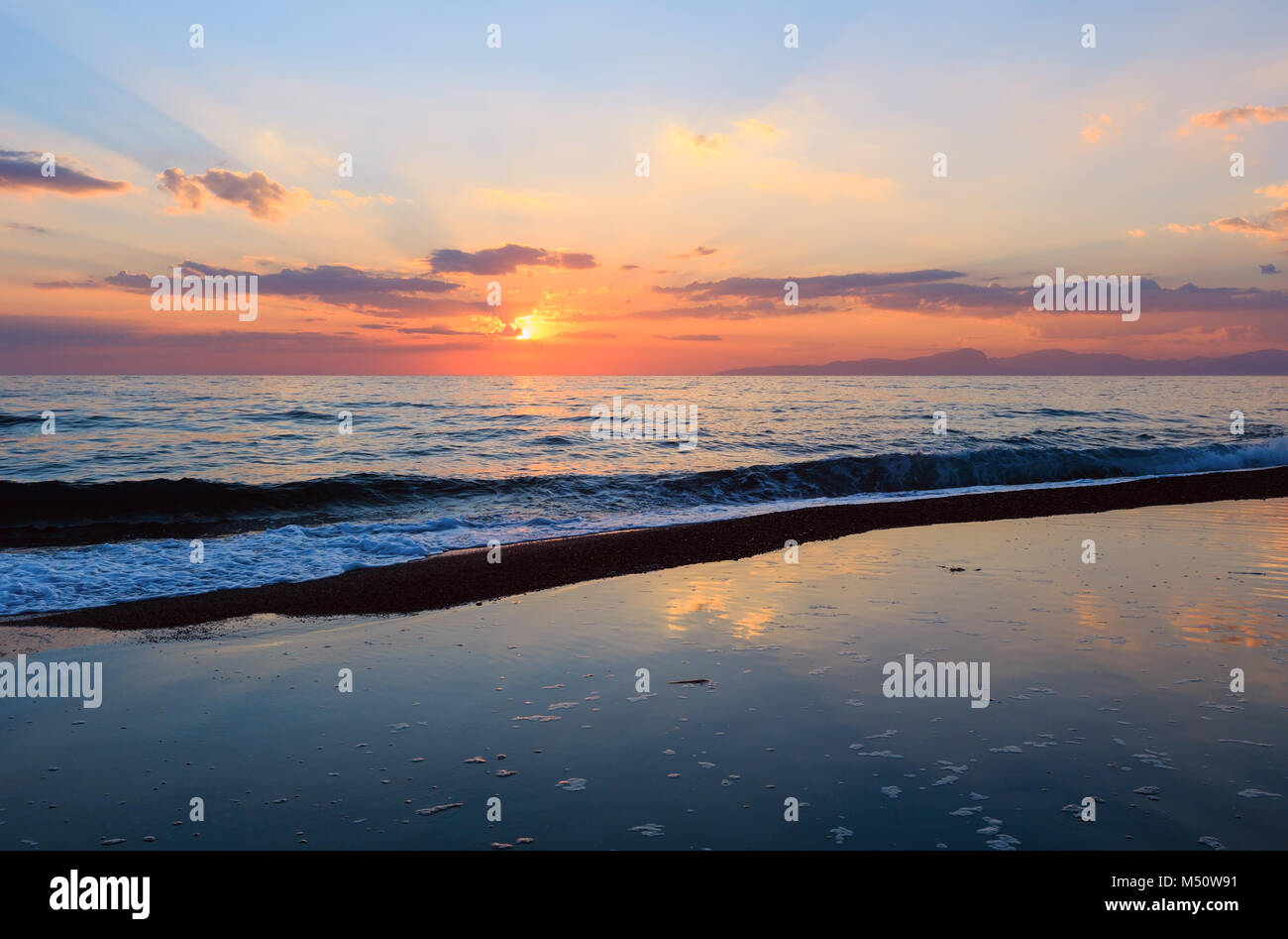 Sunset on sea beach Stock Photo - Alamy