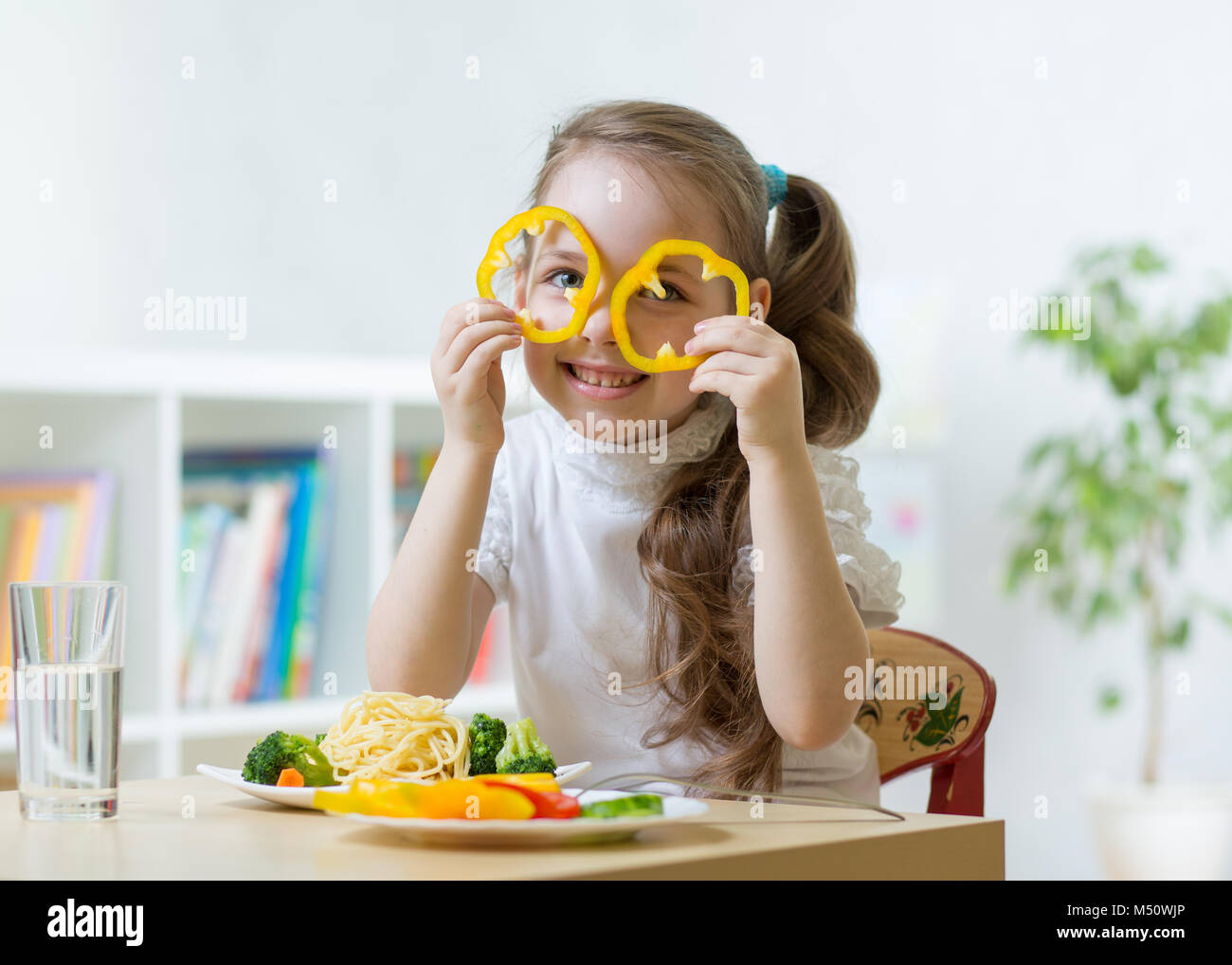 Child girl having fun with food vegetables at nursery room Stock Photo ...