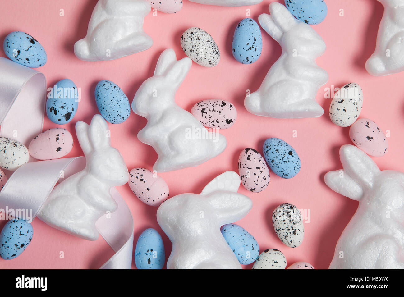 Pastel pink easter holiday background with eggs and easter bunnies ...