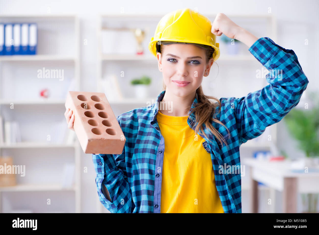 Woman with brick in construction concept Stock Photo - Alamy