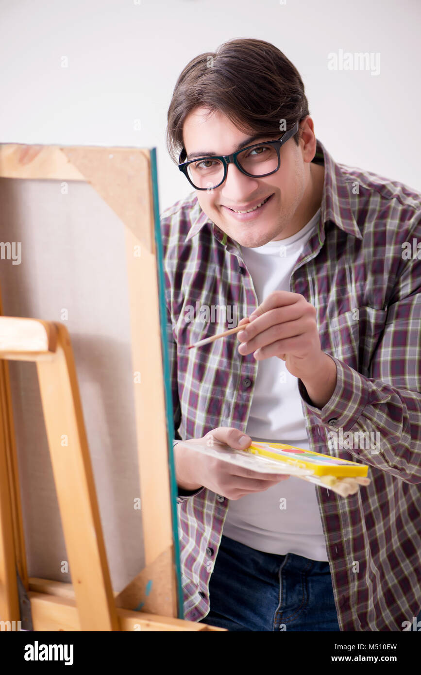 Young male artist drawing pictures in bright studio Stock Photo - Alamy