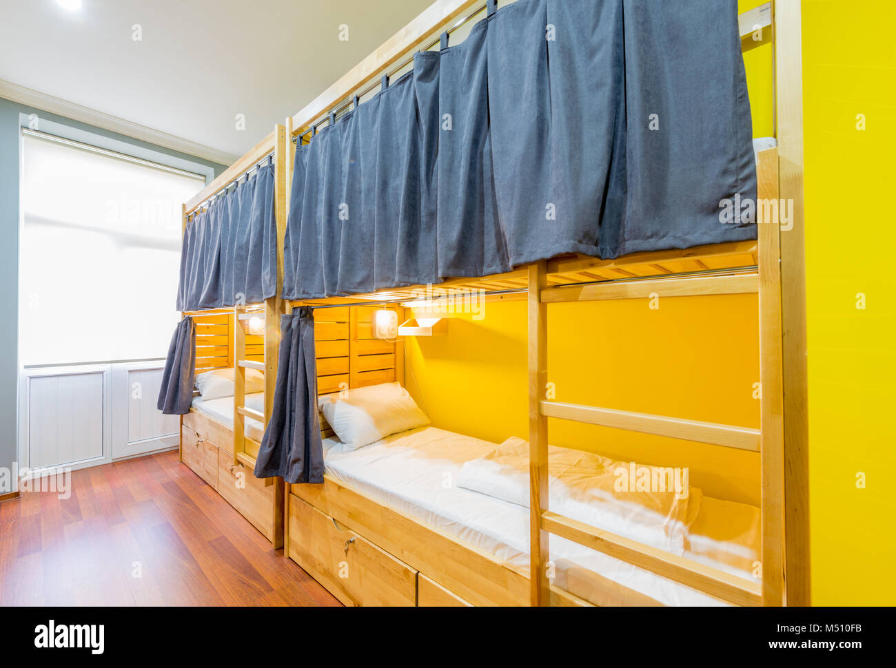 Hostel dormitory beds arranged in room Stock Photo - Alamy