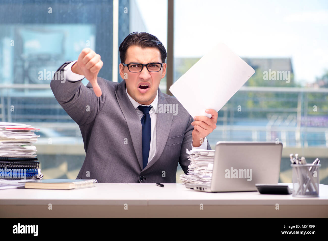 Angry businessman with too much work in office Stock Photo - Alamy