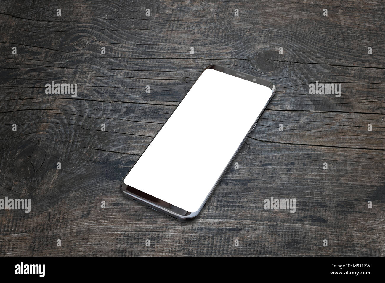 Mobile phone with isolated screen on wooden black desk. Modern smart ...