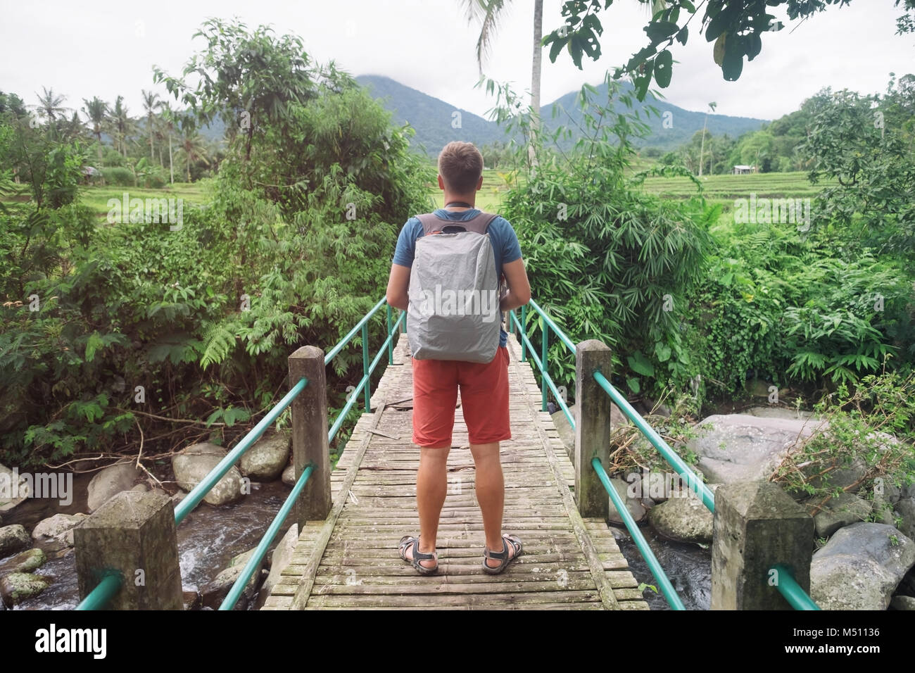 Caucasian man standing on bridge and looking ahead. Back side view ...