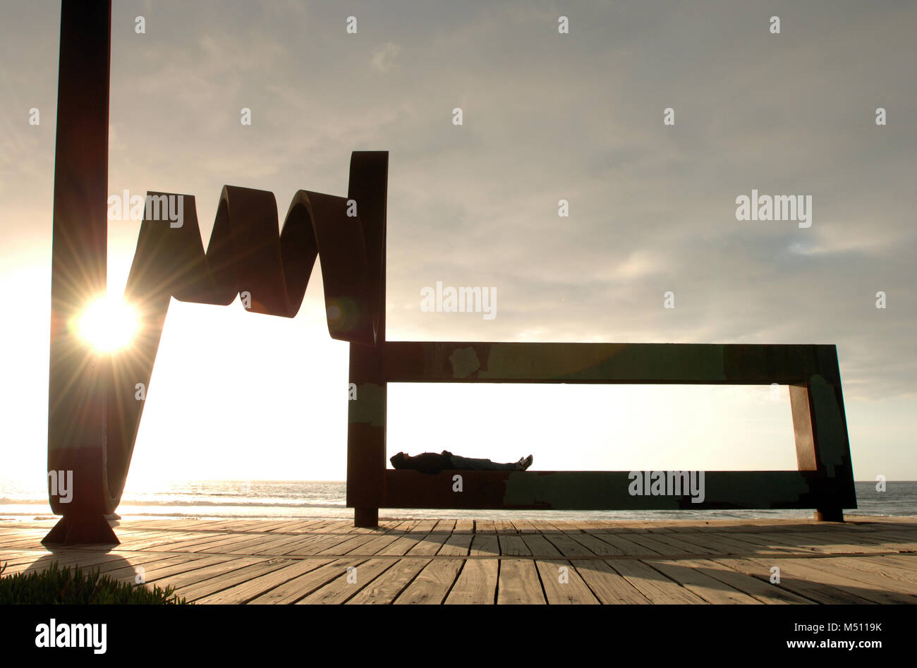 Man sleeping on steel sculpture on the promenade on Playa de Las ...