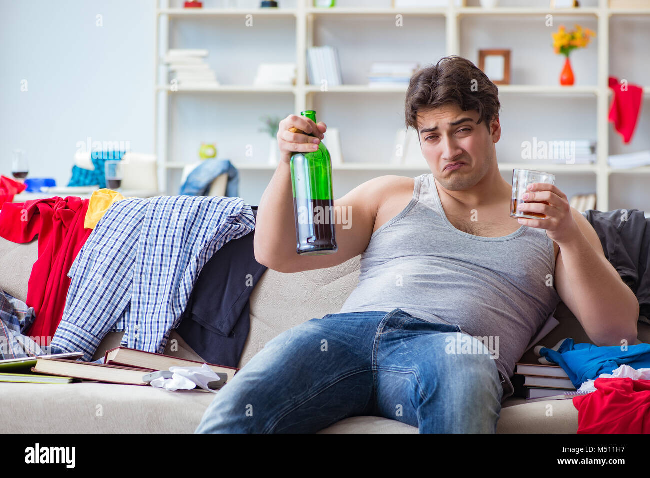 Young man student drunk drinking alcohol in a messy room Stock Photo ...