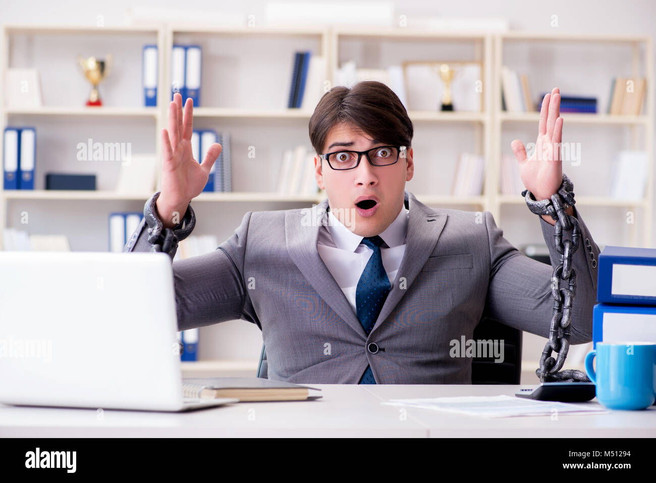 Businessman tied with chains to his work Stock Photo - Alamy