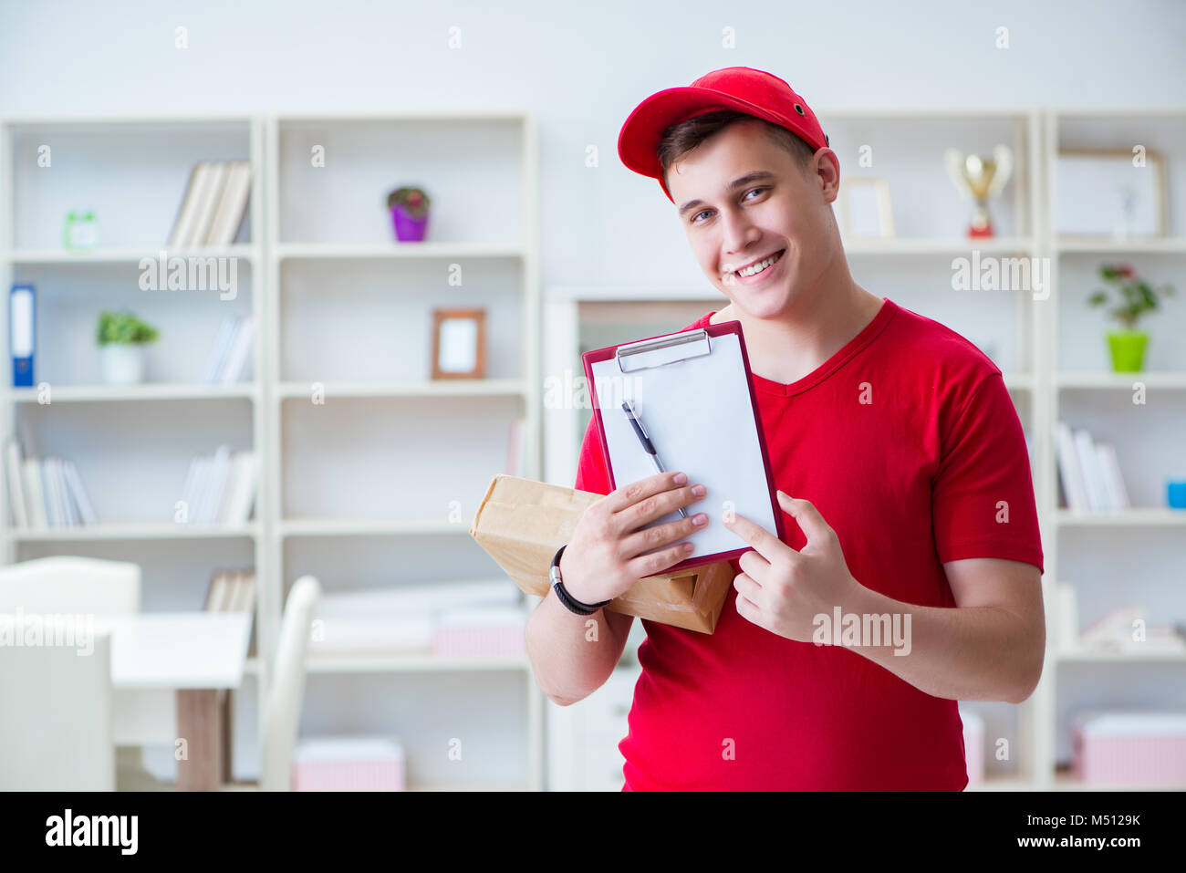 Post man delivering a parcel package Stock Photo - Alamy