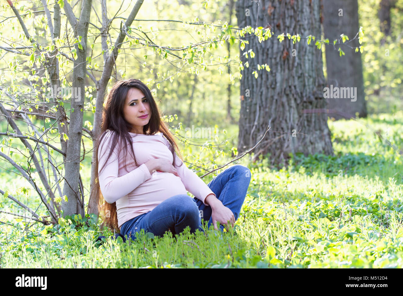 Girl sitting under a tree branch hi-res stock photography and images ...