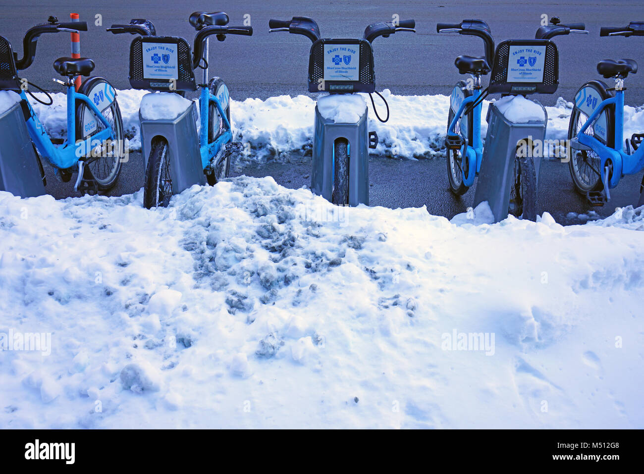 Winter in Chicago. Snow covers Divvy bike shares blue Bixi bicycles ...