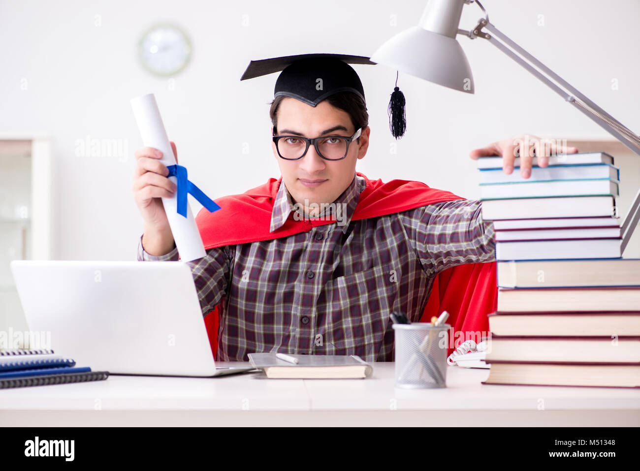Super hero student wearing a mortarboard studying Stock Photo - Alamy