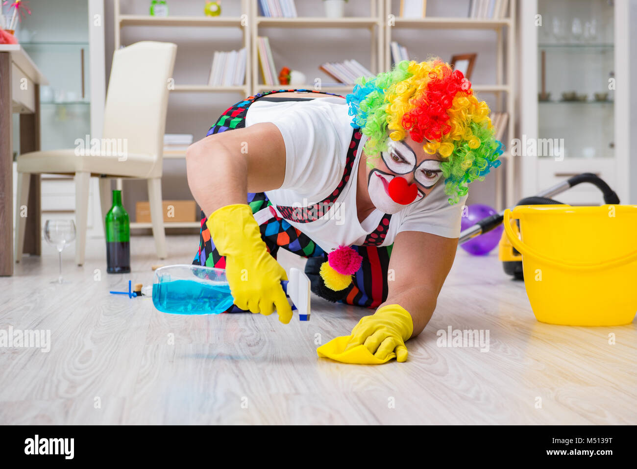 Funny clown doing cleaning at home Stock Photo - Alamy