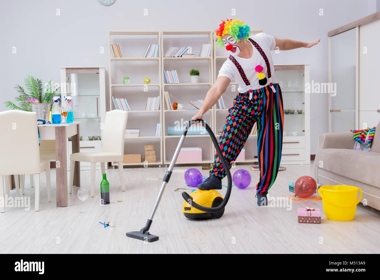 Funny clown doing cleaning at home Stock Photo - Alamy