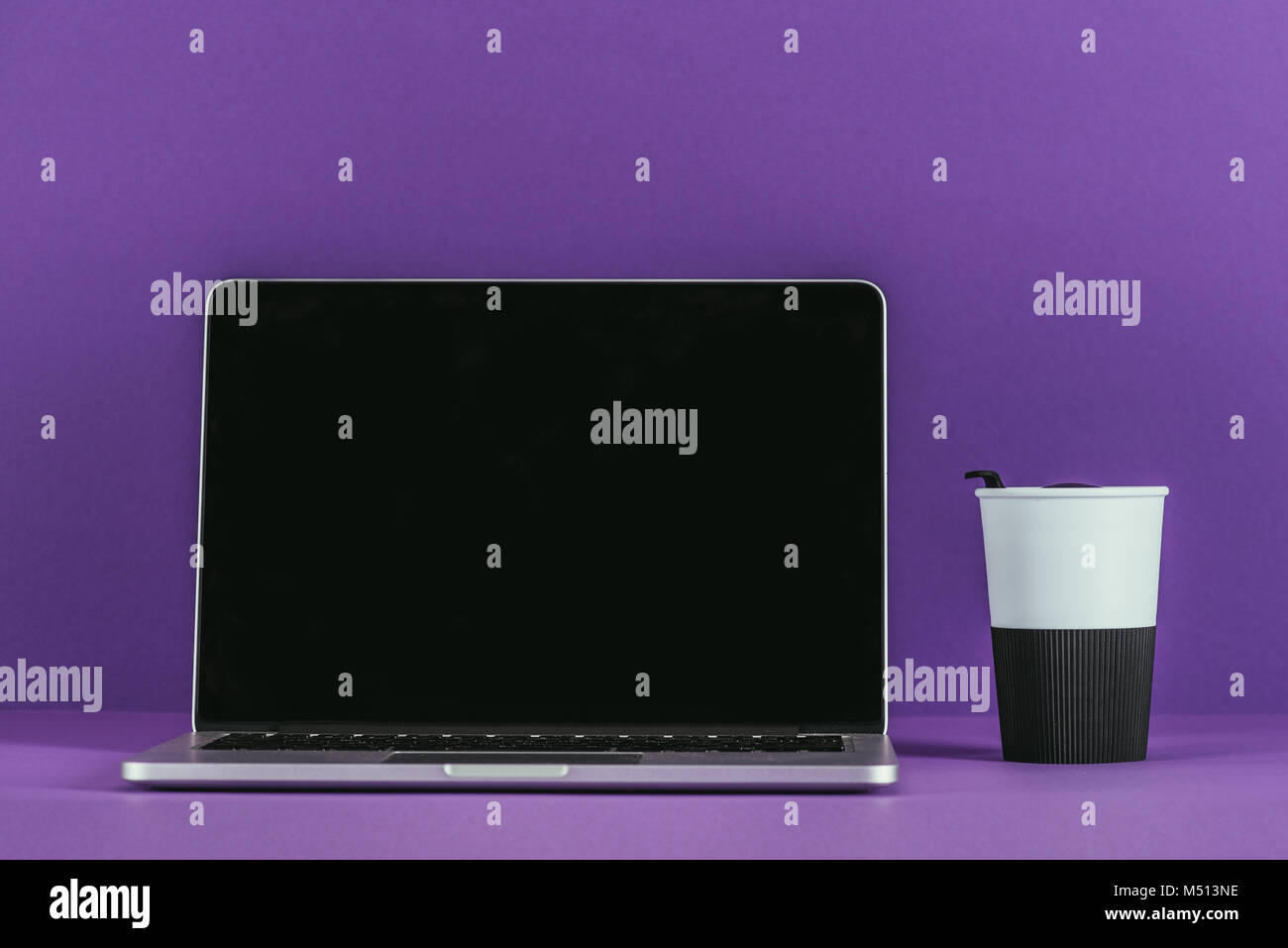 laptop with paper cup of coffee on purple surface Stock Photo - Alamy